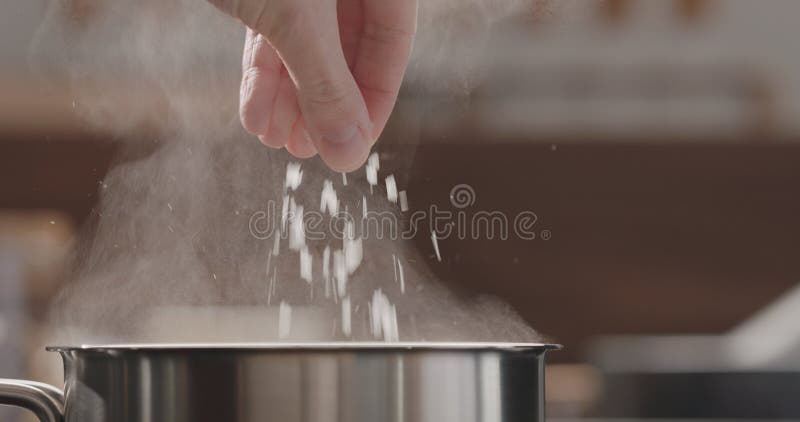 Man Adding Salt To Boiling Water in Saucepan Stock Image - Image of ...