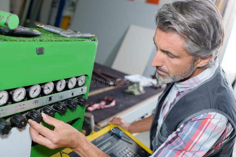 Man Adjusting Controls on Industrial Machine Stock Photo - Image of ...