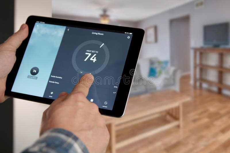 Man is Adjusting a Temperature Using a Tablet with Smart Home App in ...