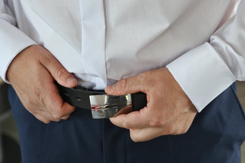 The man adjusts his belt stock image. Image of belt - 183161937