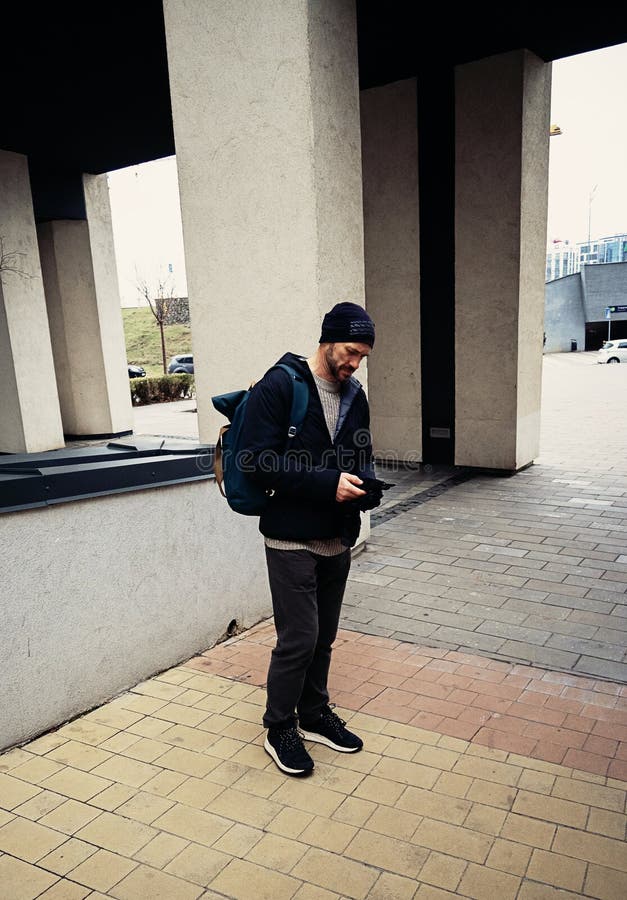 A Man Against the Backdrop of Modern Urban Architecture. he is Dressed ...