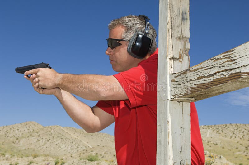 Man Aiming Hand Gun at Firing Range Stock Image - Image of profile ...