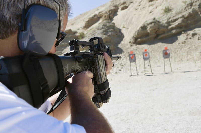 Man and Woman Aiming Hand Guns at Firing Range Stock Image - Image of ...