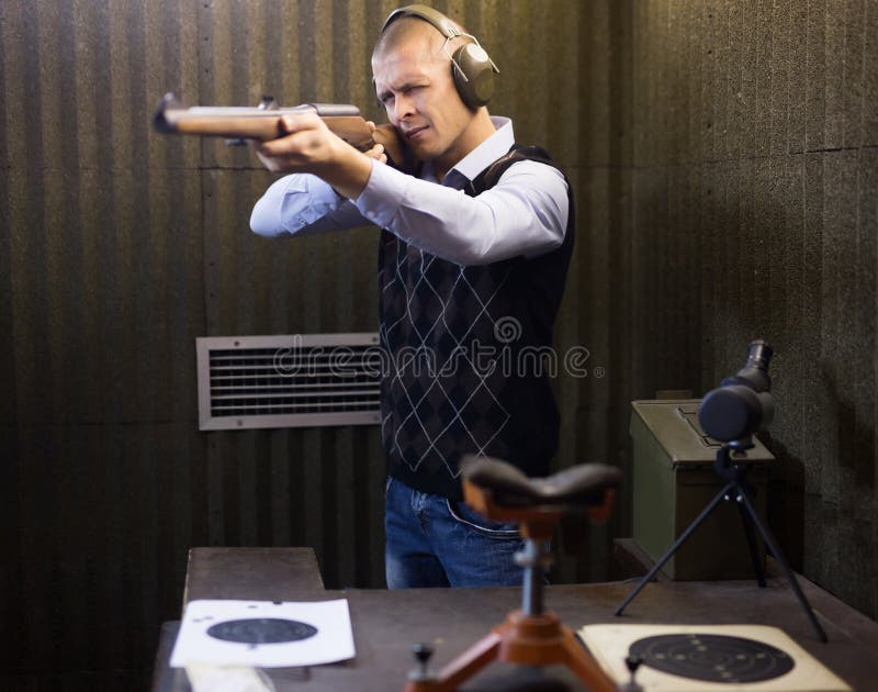 Man Aims at a Target with a Semi-automatic Rifle in Shooting Range ...