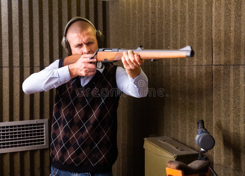 Man Aims at a Target with a Semi-automatic Rifle in Shooting Range ...