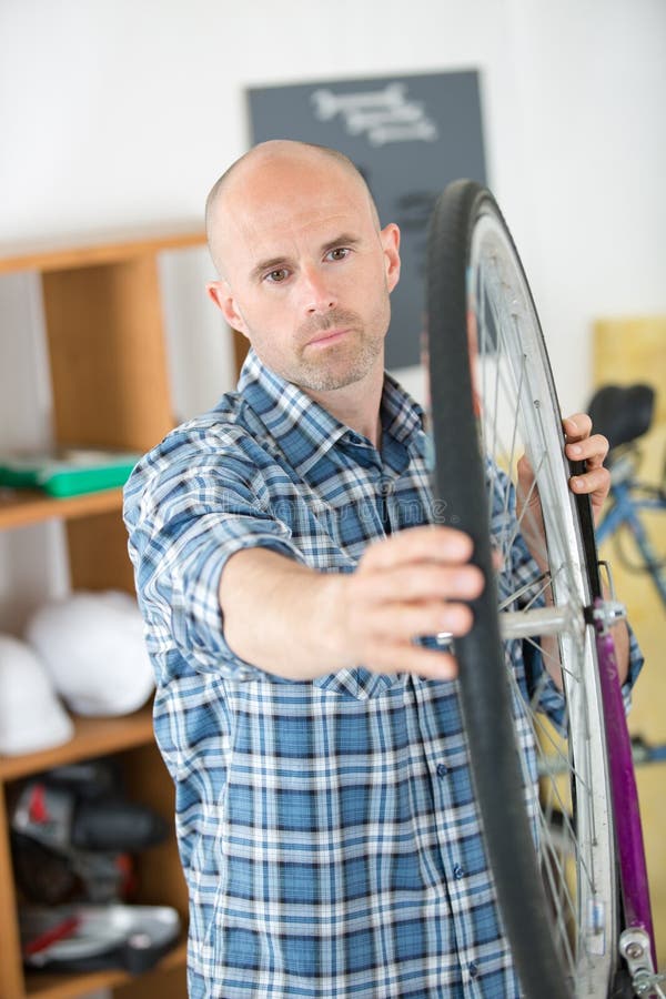 Man aligning bicycle wheel stock image. Image of spokes - 120358453