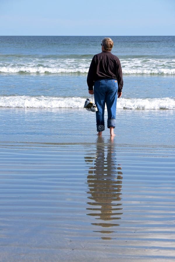 Wading alone on the beach stock photo. Image of bare - 160109612