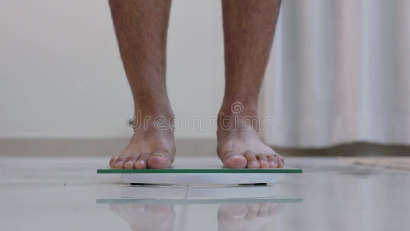The Man Analyzing Weight while Standing on Weight Scale Stock Footage ...