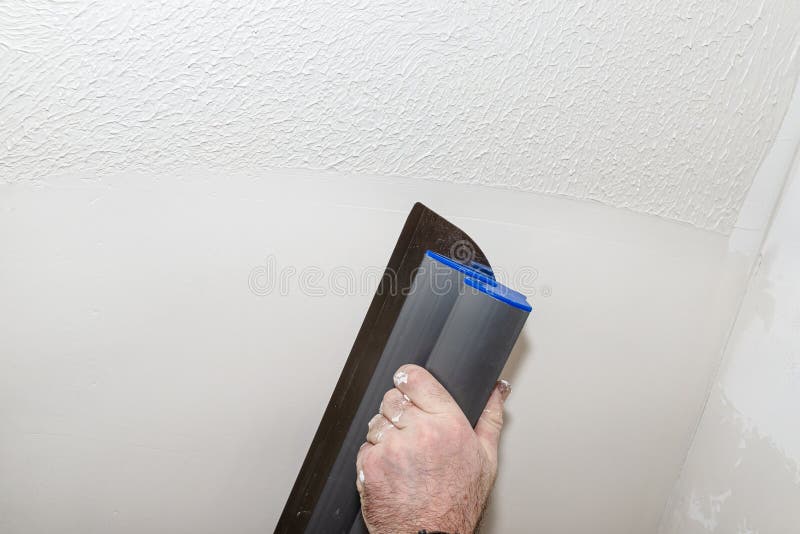 A Man Applies Ready-made Polymer Plaster from a Bucket Using Special ...