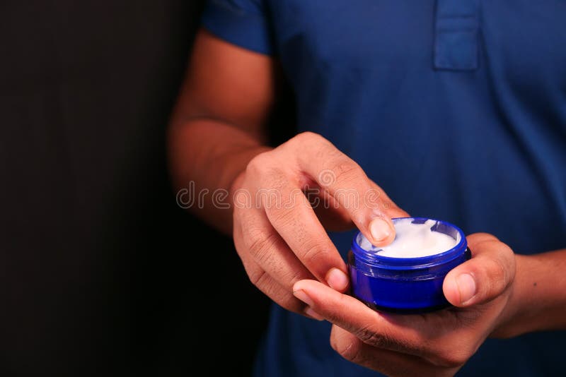 Man Applying Beauty Cream Onto Skin in Black Stock Photo - Image of ...