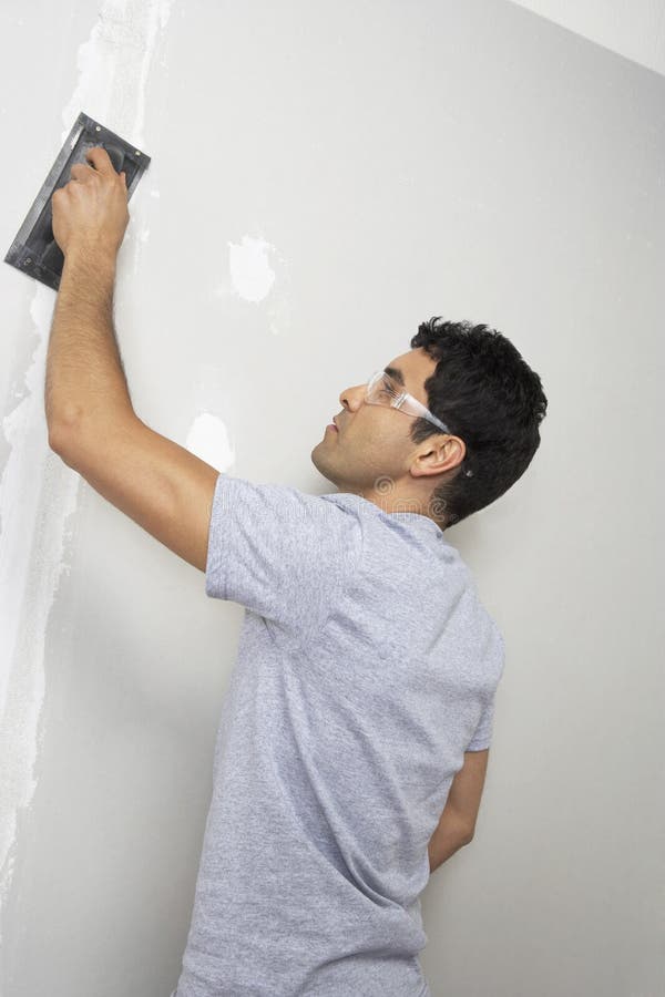 Man Applying Putty on Wall stock photo. Image of filler - 29651556