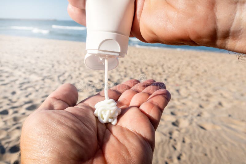 Man Applying Sunscreen Cream To His Hands on the Beach Stock Image ...