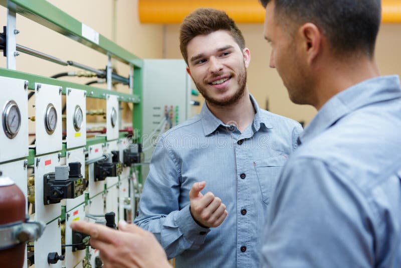 Man with Apprentice Checking Machine Stock Photo - Image of ...