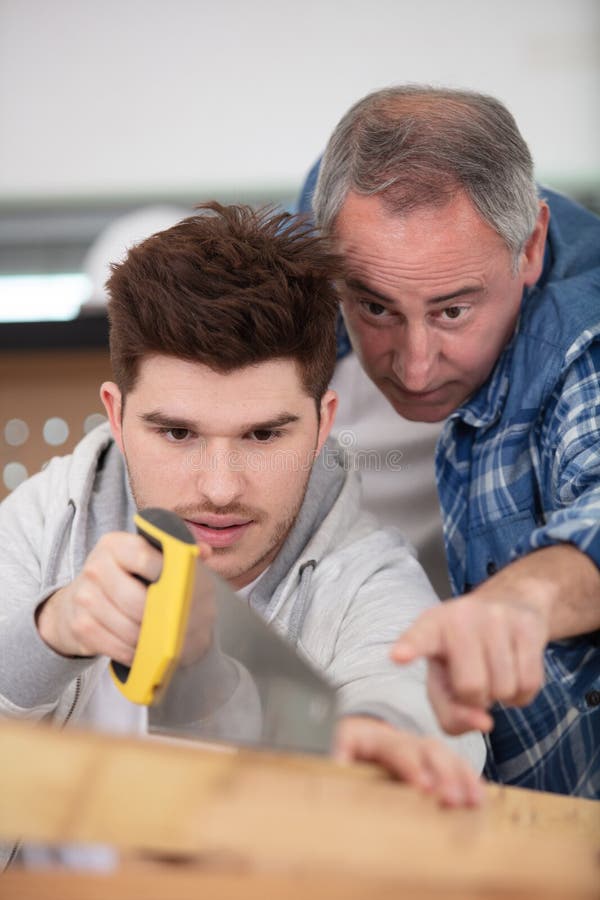 Man and Apprentice Learning To Cut Wood Stock Image - Image of persons ...