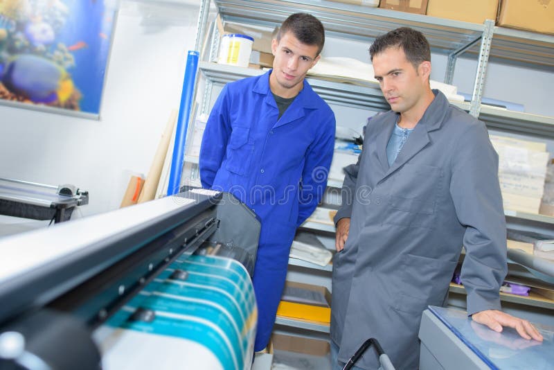 Man and Apprentice Watching Printing Machine Stock Photo - Image of ...