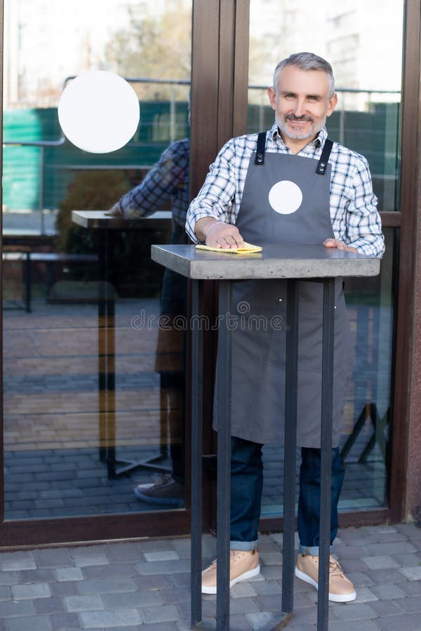 Man in Apron Cleaning the Tables in a Street Cafe Stock Photo - Image ...