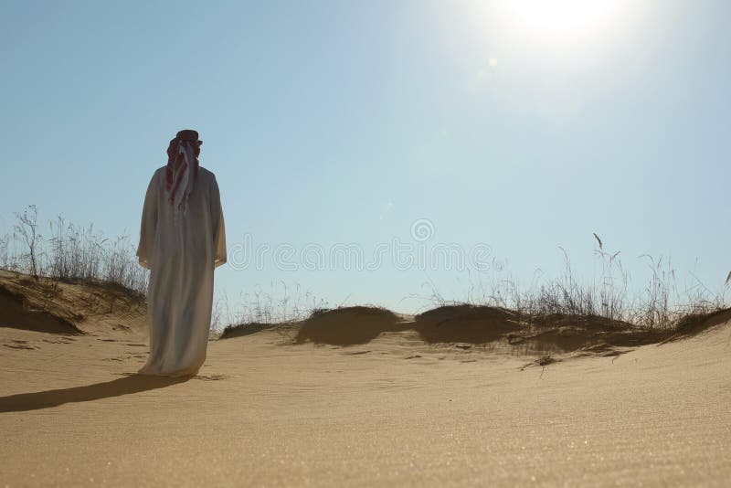Man in Arabic Clothes Walking through Desert on Sunny Day, Back View ...