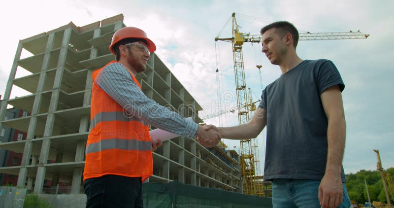 Man Architects Engineers and Male Client Shaking Hands at Construction Site. Professions ...