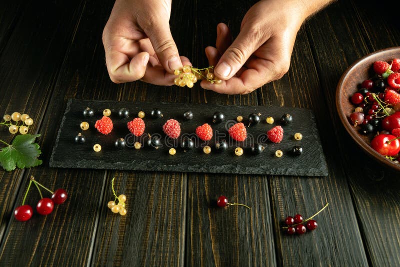 A Man Arranging Ripe Berries on a Black Sorting Board before Serving ...