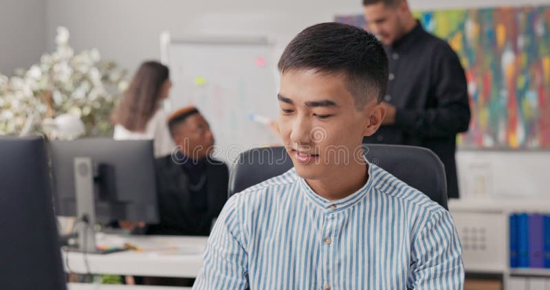 A Man of Asian Korean Beauty Sits in Front of an Office Computer, Using ...
