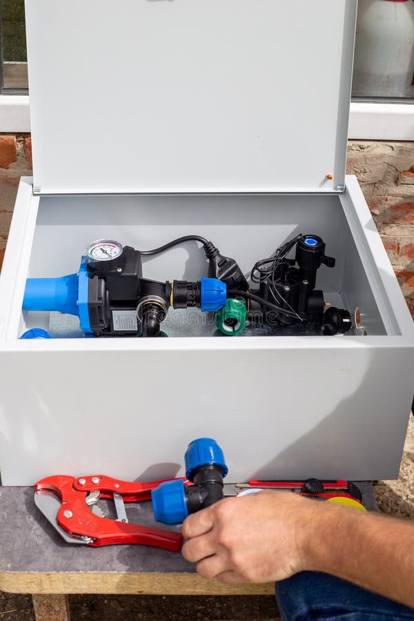 A Man Assembles a Drip Irrigation System by Arranging the Elements of ...