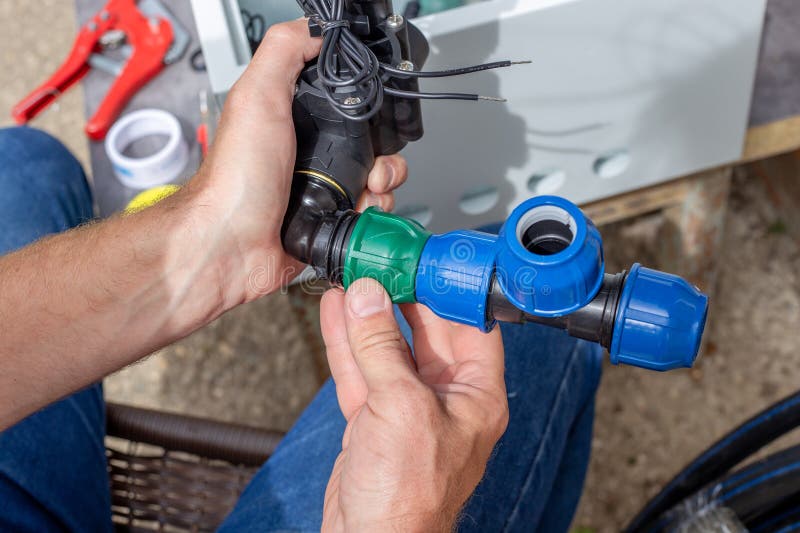 A Man Assembles a Drip Irrigation System by Connecting Pipeline ...