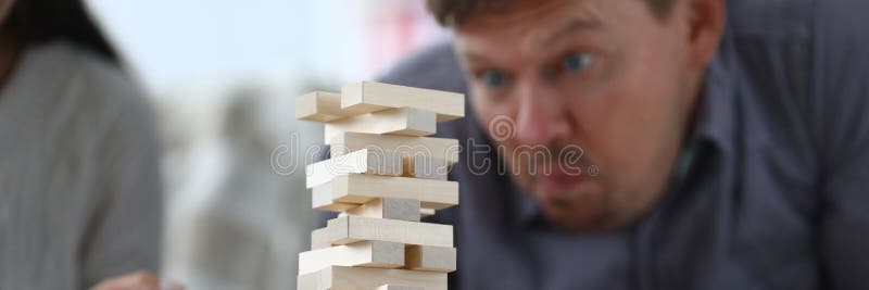 Man Assembles a Tall Tower from Wooden Rectangular Blocks Stock Image ...
