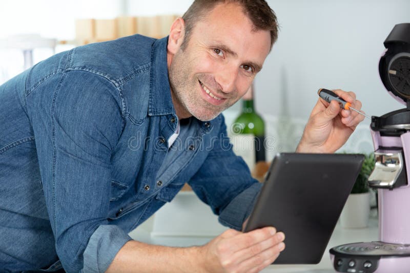Man Assembling Appliance Following Instructions on Tablet Stock Photo ...
