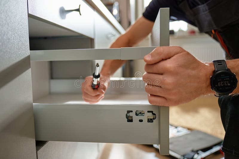Carpenter Installing and Adjusting Drawer Front in Modern Kitchen ...