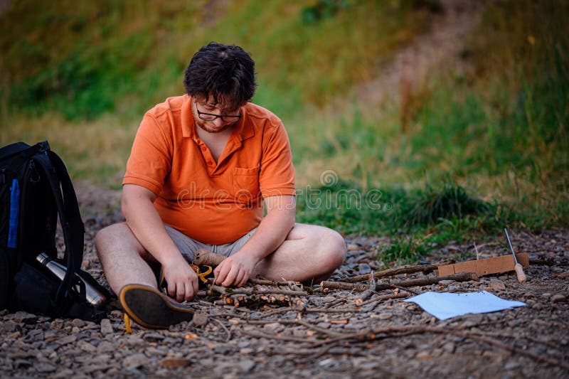 Man Assembling a Mini Raft with Sticks and String Stock Photo - Image ...