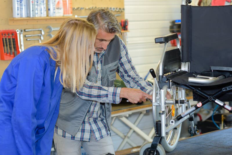 Man assembling wheelchair stock photo. Image of bench - 161830826