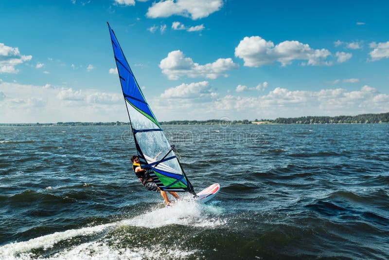 The Man Athlete Rides the Windsurf Over the Waves on Lake Stock Image ...