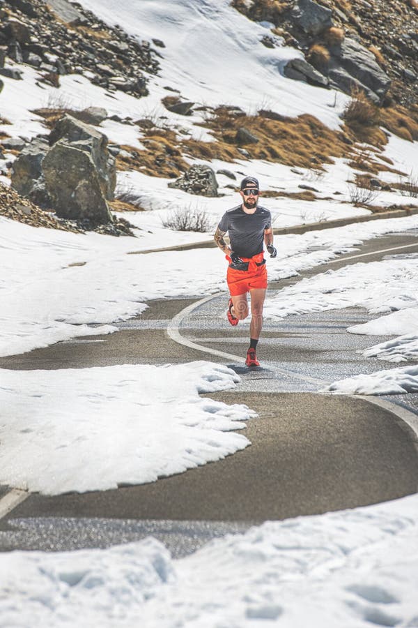 A Man Athlete Runs on a Road through an Alpine Pass Stock Image - Image ...