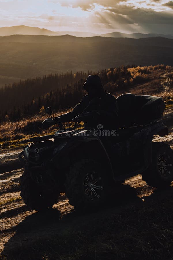 Man on ATV is Driving Offroad in Mountains during Autumn Sunset Time ...