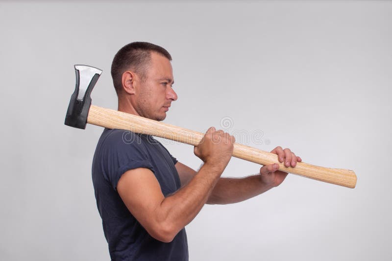 A Man with a Large Axe for Chopping Firewood on a Gray Background ...