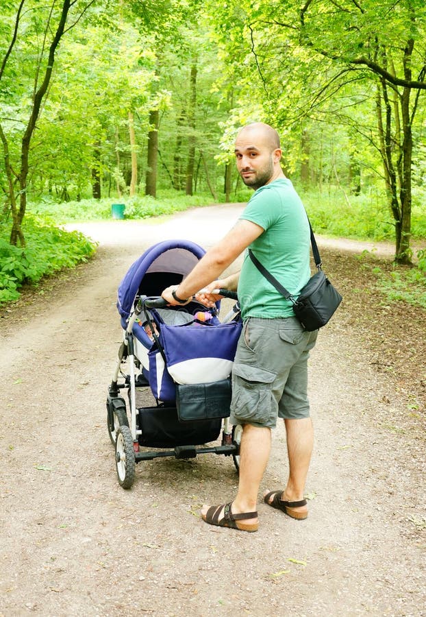 Man with baby buggy stock image. Image of path, father - 42030511