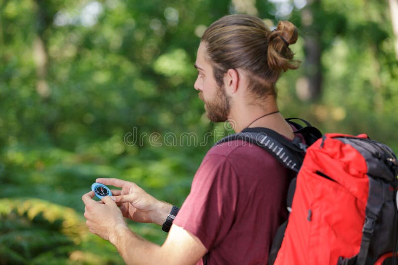 Man with Backpack Looking at Direction on Compass Stock Photo - Image ...