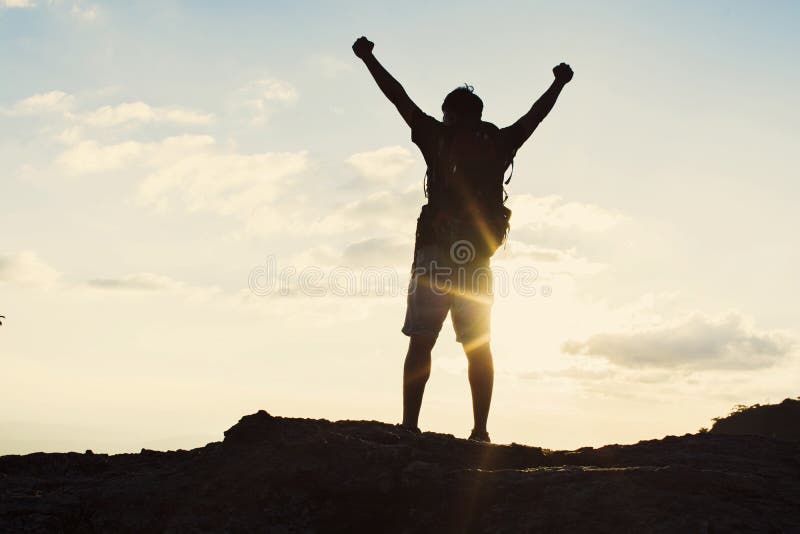 Man with Backpack Putting His Hands Up and Standing on Cliff at Stock ...