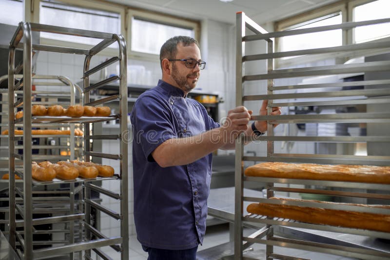 Man Baker with Trays of Fresh Bread in Bakery. Stock Photo - Image of ...