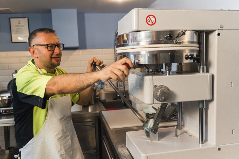 Man Baker Using a Press Machine To Make Pizza, Modern Bakery Machine ...
