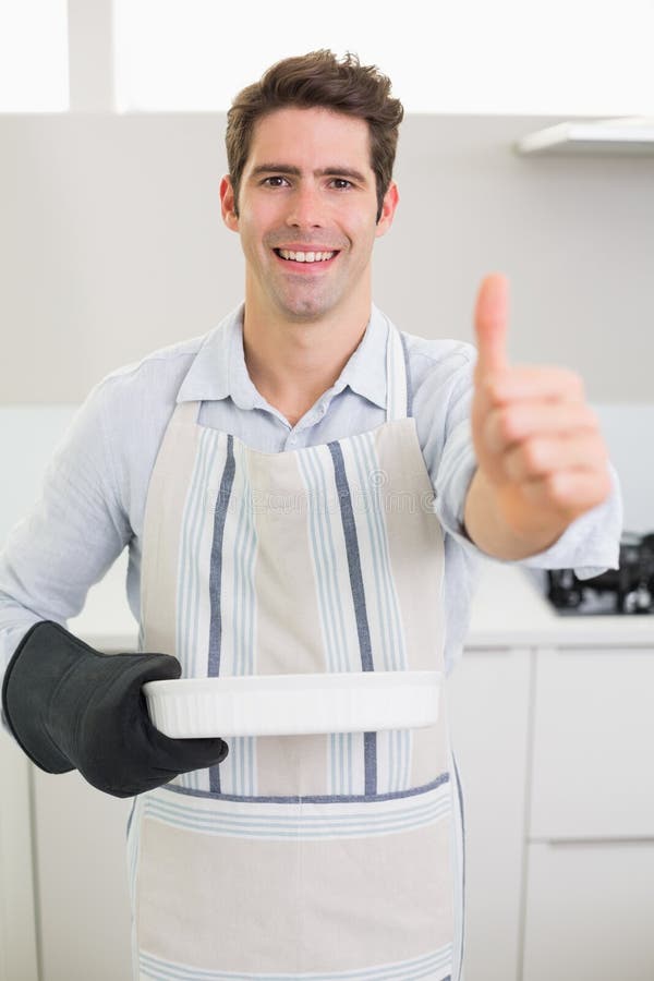 Man with Baking Dish Gesturing Thumbs Up in Kitchen Stock Image - Image ...