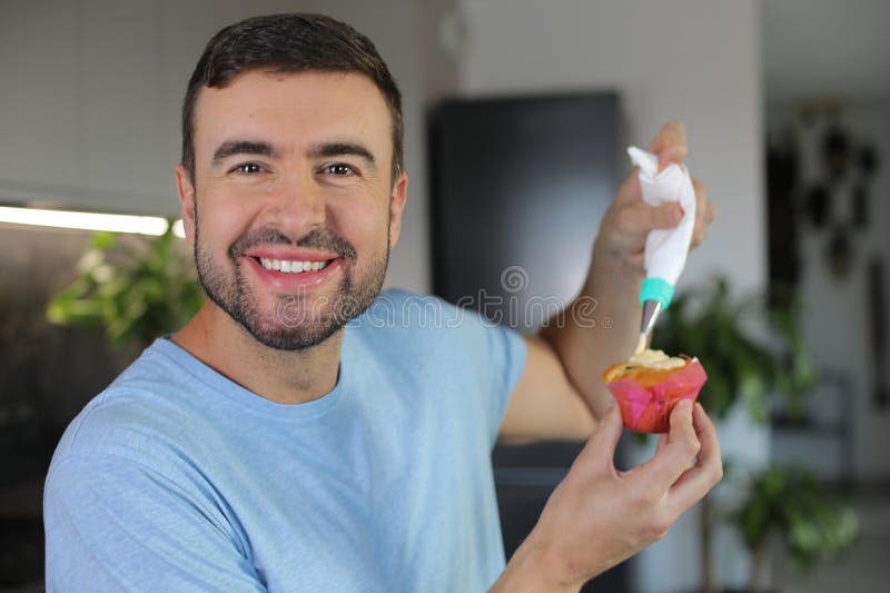 Man Baking a Muffin and Adding Some Cream To it Stock Photo - Image of ...