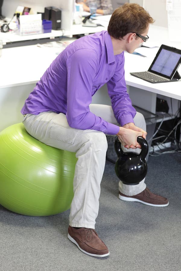 Man on Ball Working Out with Kettlebell during Offce Work Stock Photo ...