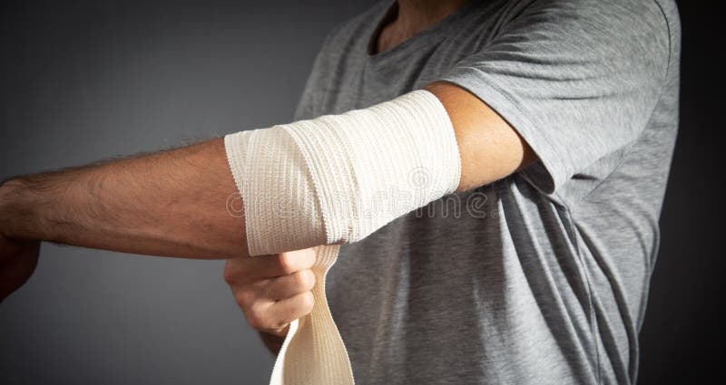 Man Bandaging an Elbow. First Aid and Medicine Concept Stock Photo ...