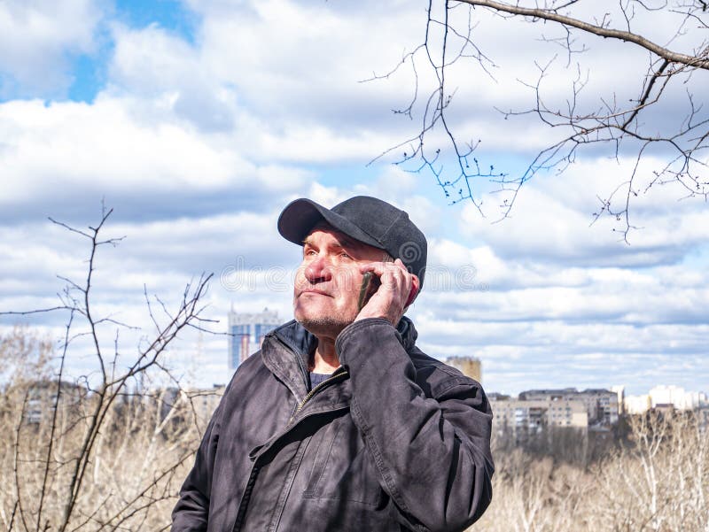 A Man in a Baseball Cap is Talking on a Cell Phone Stock Image - Image ...