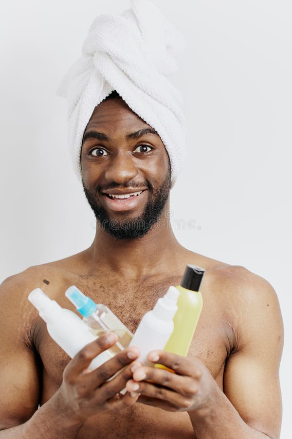 Man in Bathroom Towel Holding Lotion and Shampoo Bottles, Ready for ...