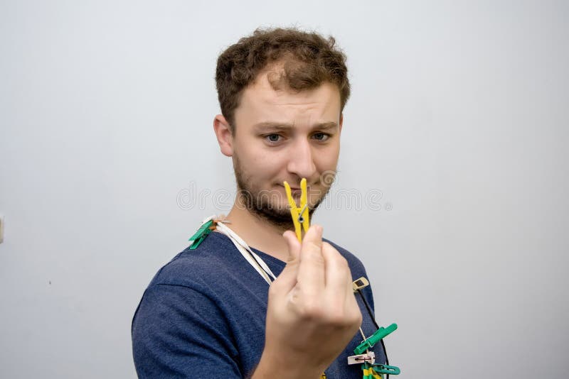 A Man with a Beard Looks at a Clothespin, Going To Hang Clothes, Doing ...