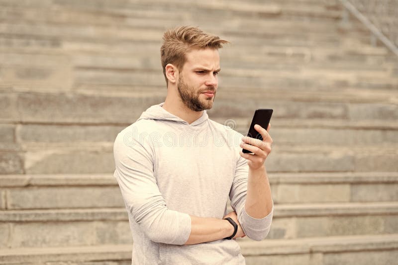 Man With Beard Walks With Smartphone Urban Background With Stairs