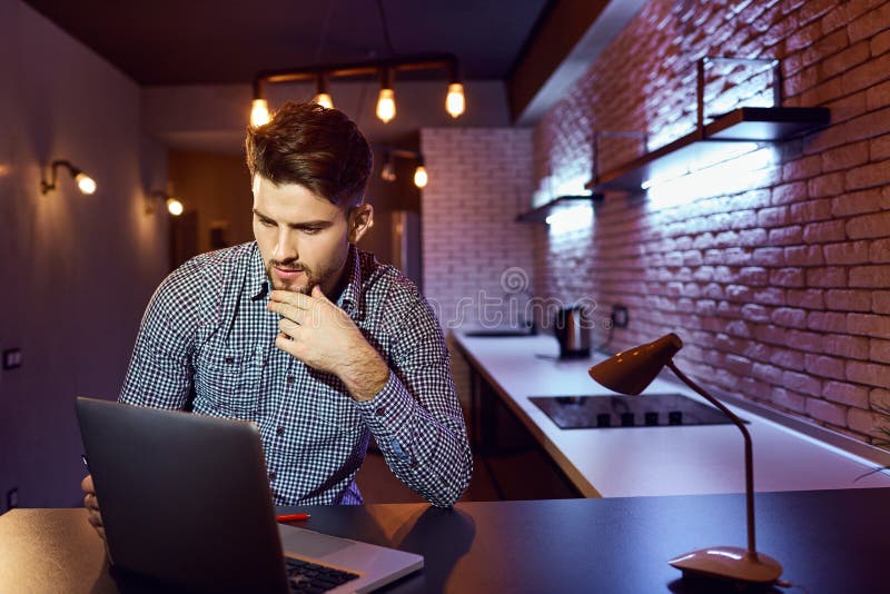 A Man Freelancer with a Laptop Works in the Evening. Stock Photo ...