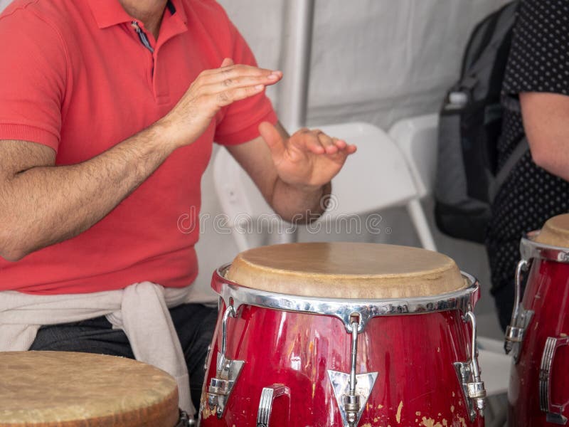 Man Beats on Red Conga Drum with Bare Hands with Crowd Stock Image ...